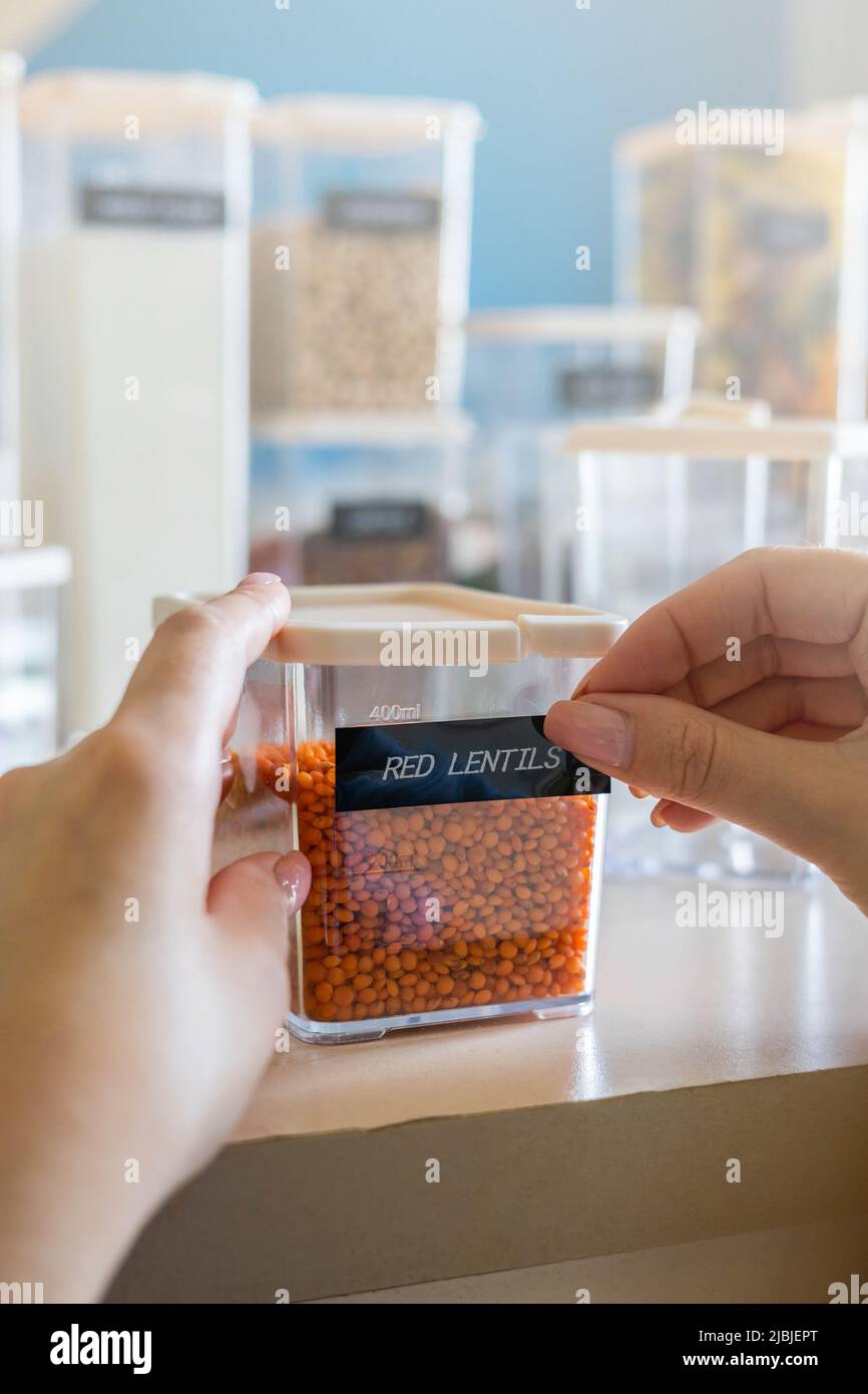 Closeup female hands applying printing sticker with name red lentils on ...