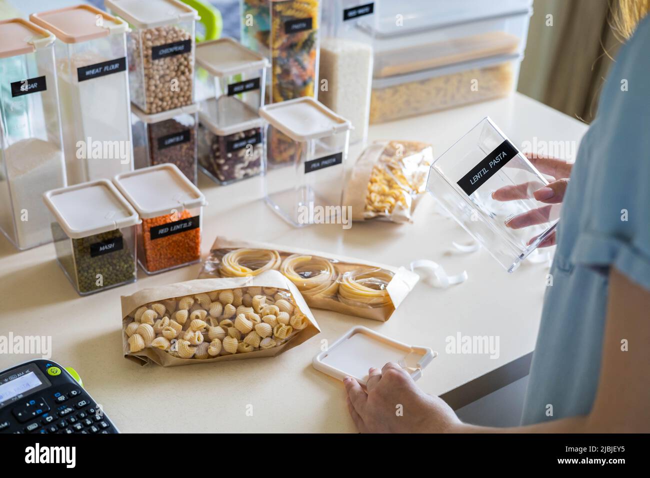 Top view woman hands sticking label marker on transparent plastic box ...