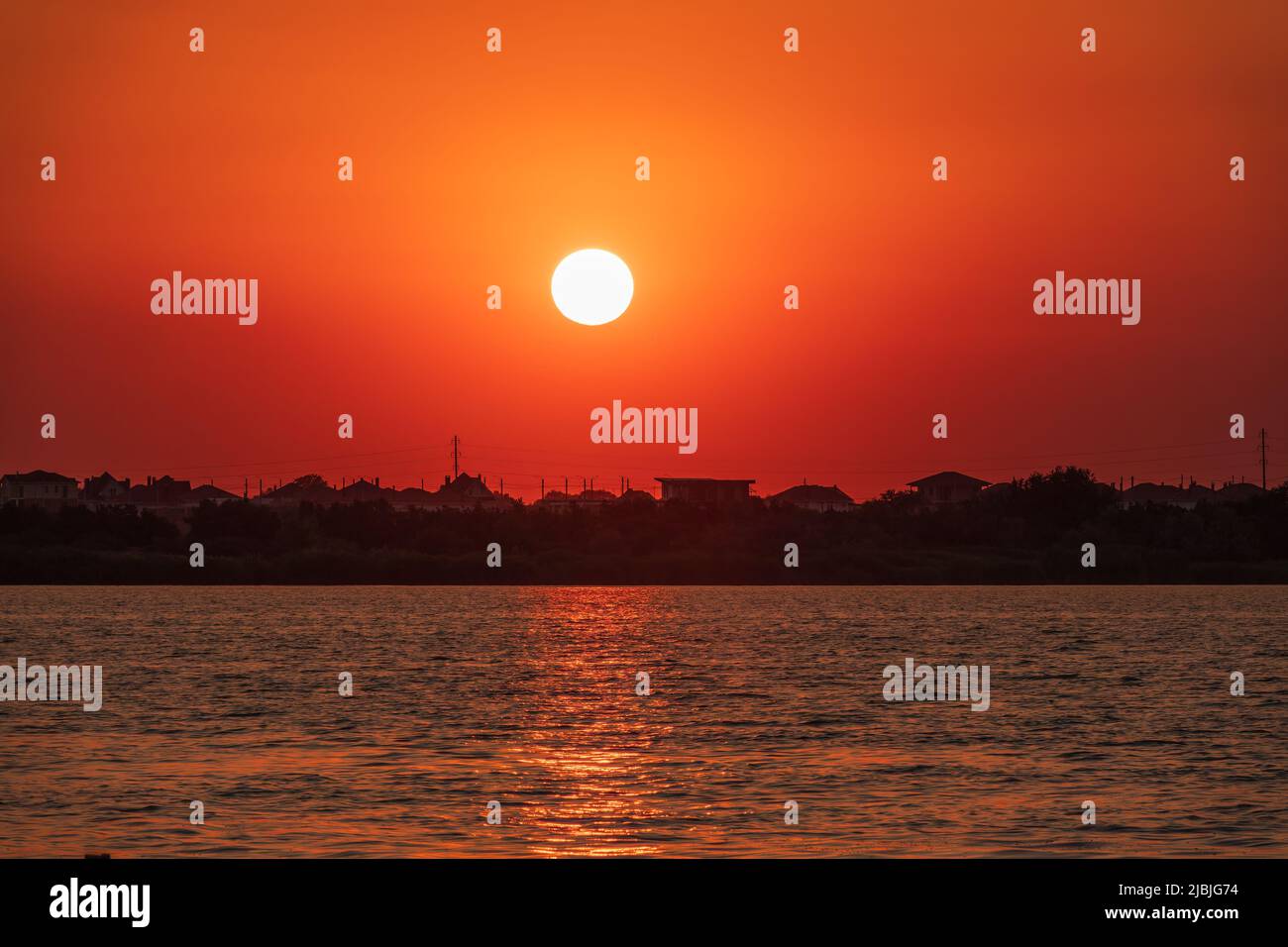 The sun goes down over a lake. Dramatic Sunset Sky Stock Photo - Alamy