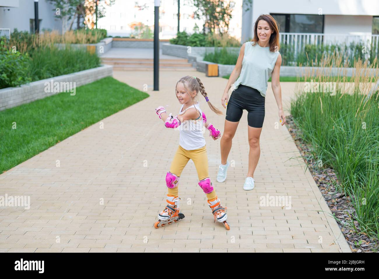Caucasian woman teaches her daughter to skate on roller skates Stock ...