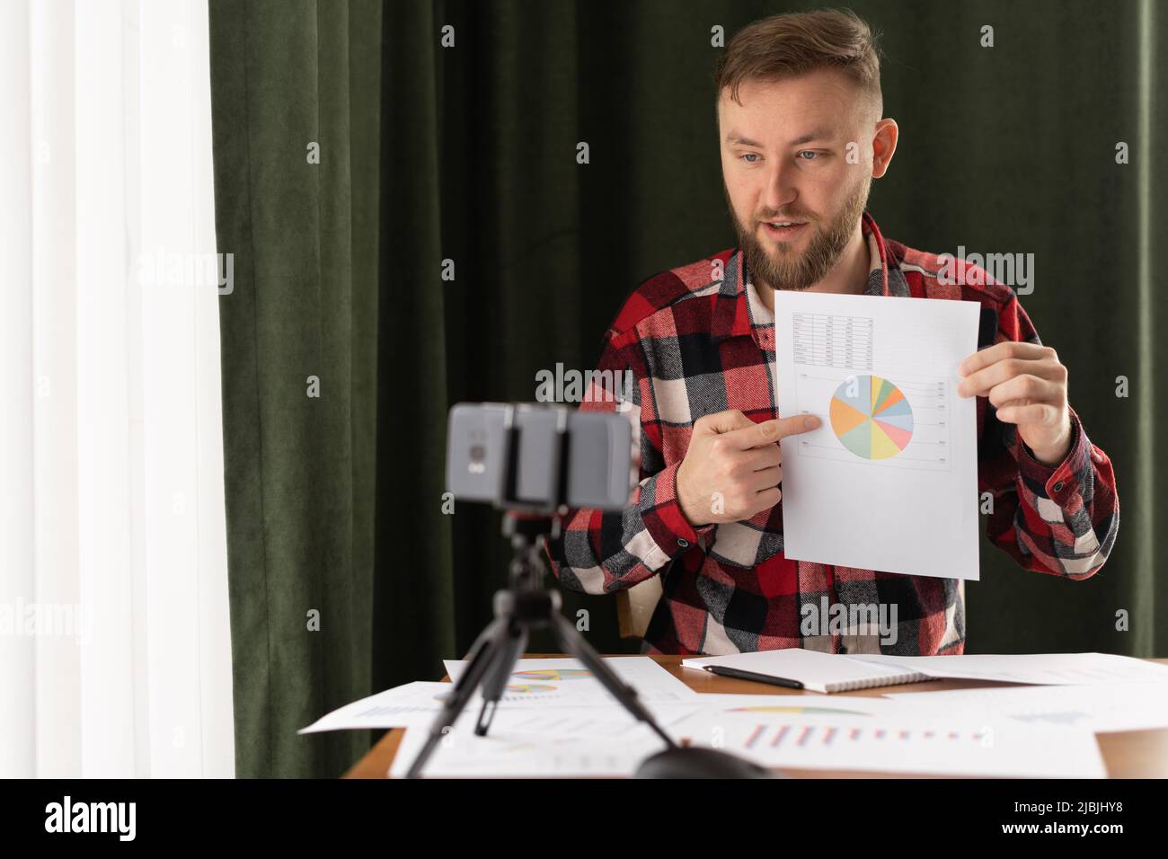 Young man making business presentation and demonstrating graphs ...