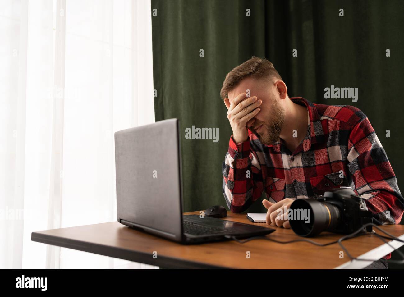 Frustrated Photographer off loading files on laptop. Checking photos ...