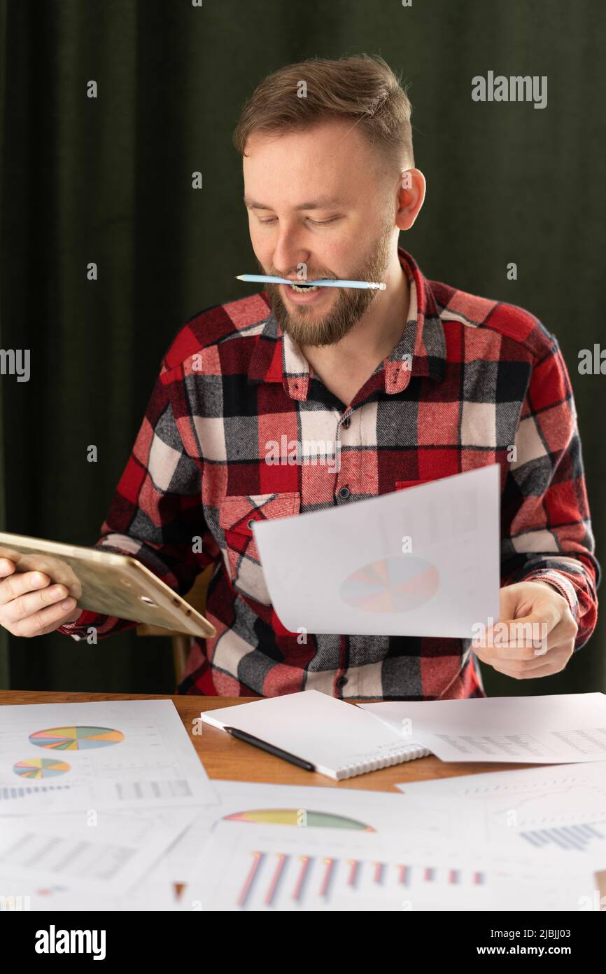 Work with papers. Serious millennial male entrepreneur working in ...