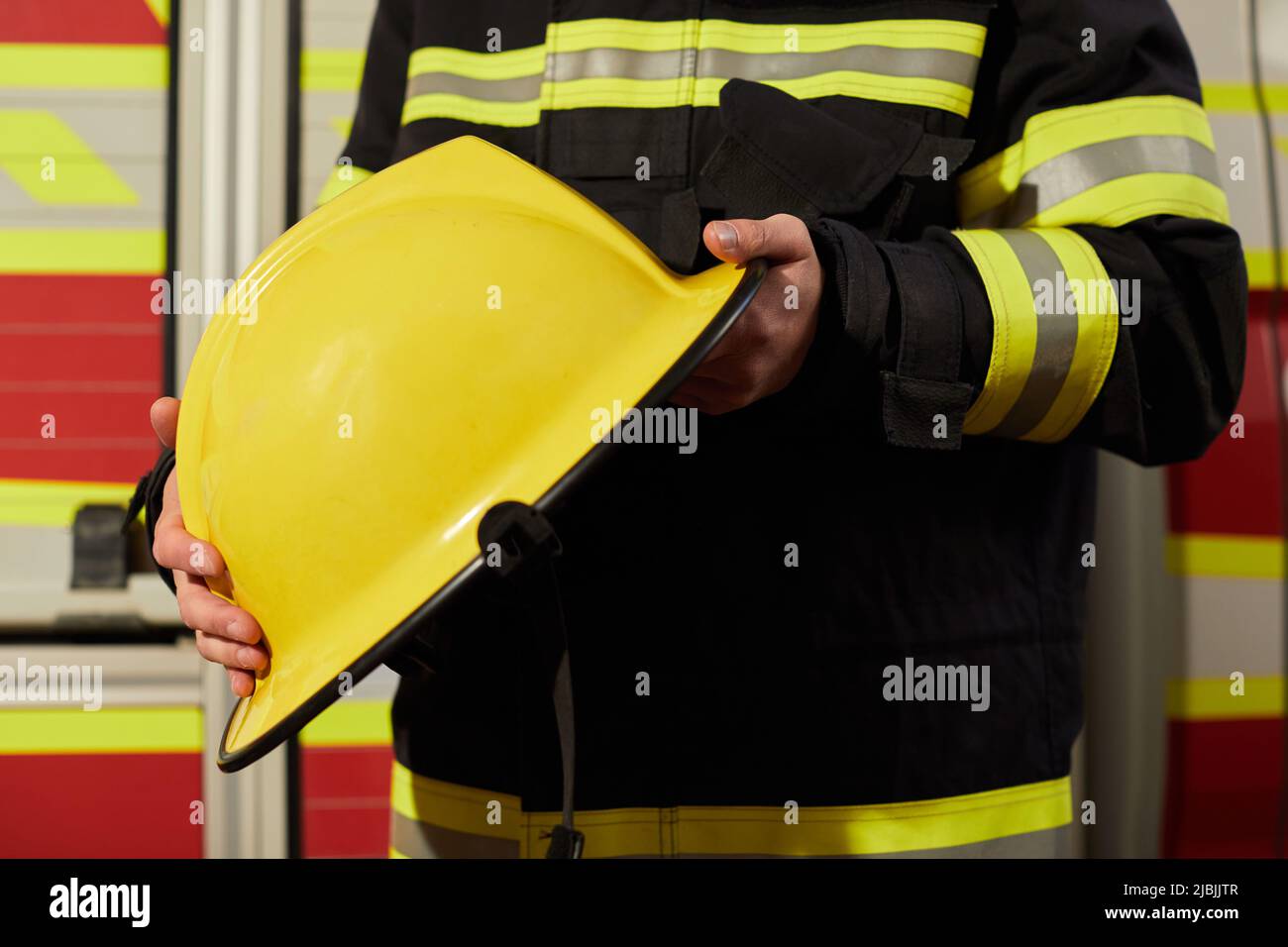 Close up image of a firefighter's helmet. Firefighter holding a yellow ...