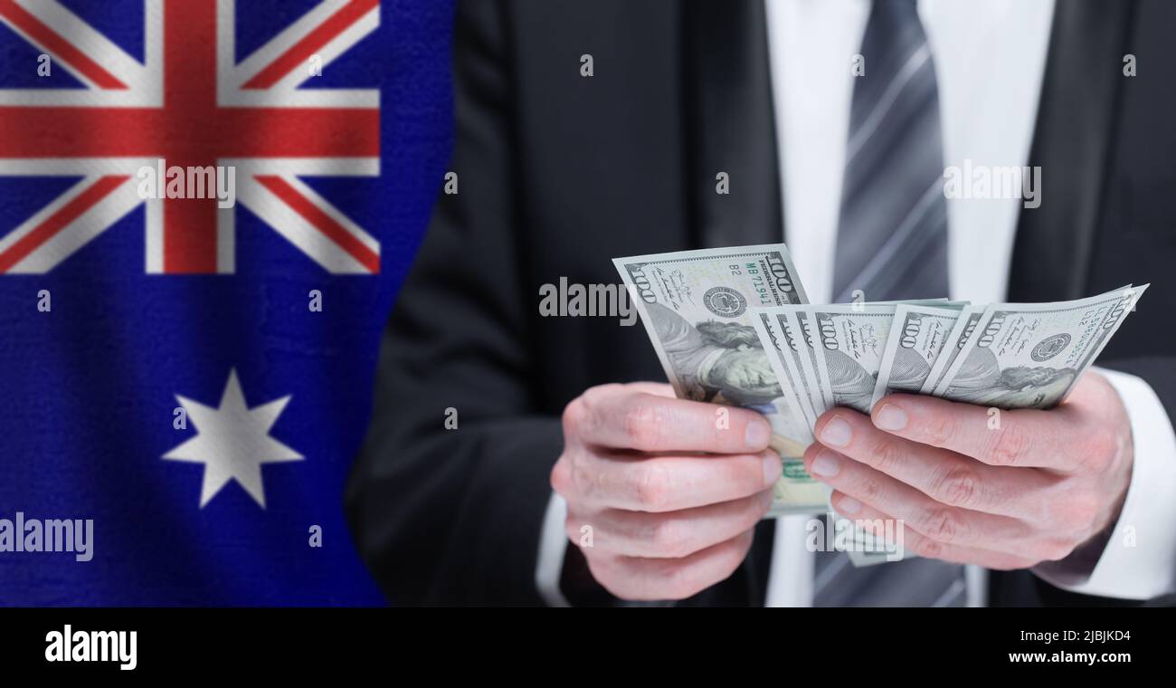Hands holding dollar money on flag of Australia Stock Photo - Alamy