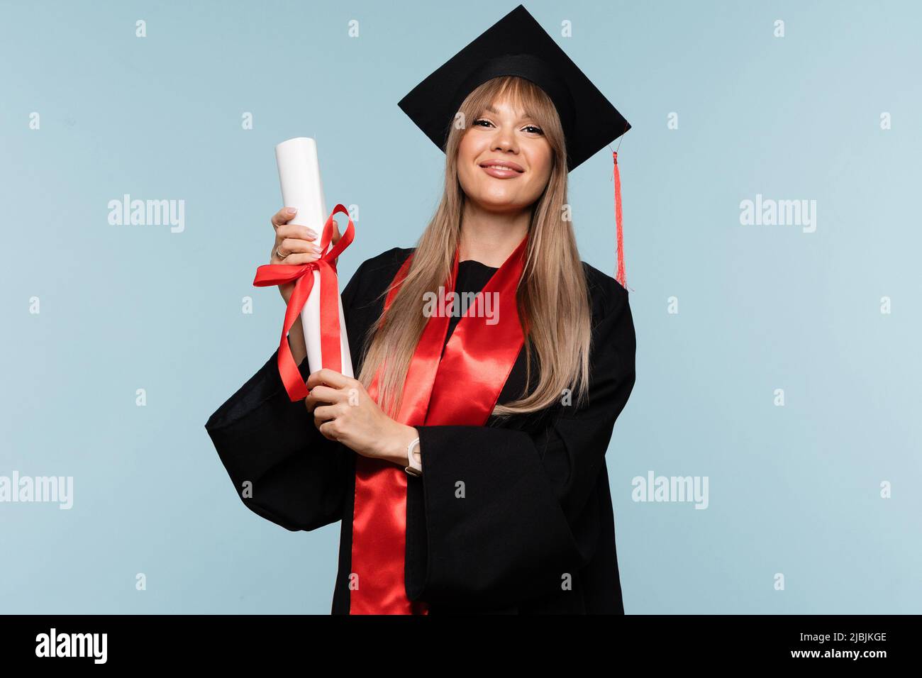 Girl graduate in graduation hat with diploma on light blue background ...
