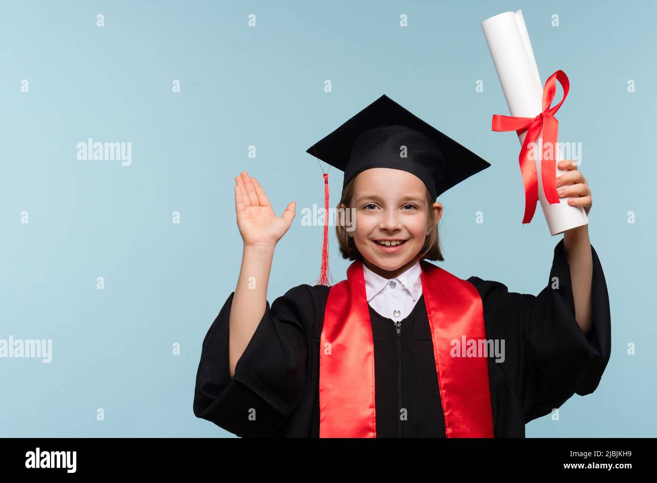 Smiling happy proud child girl in graduate suit with certificate ...