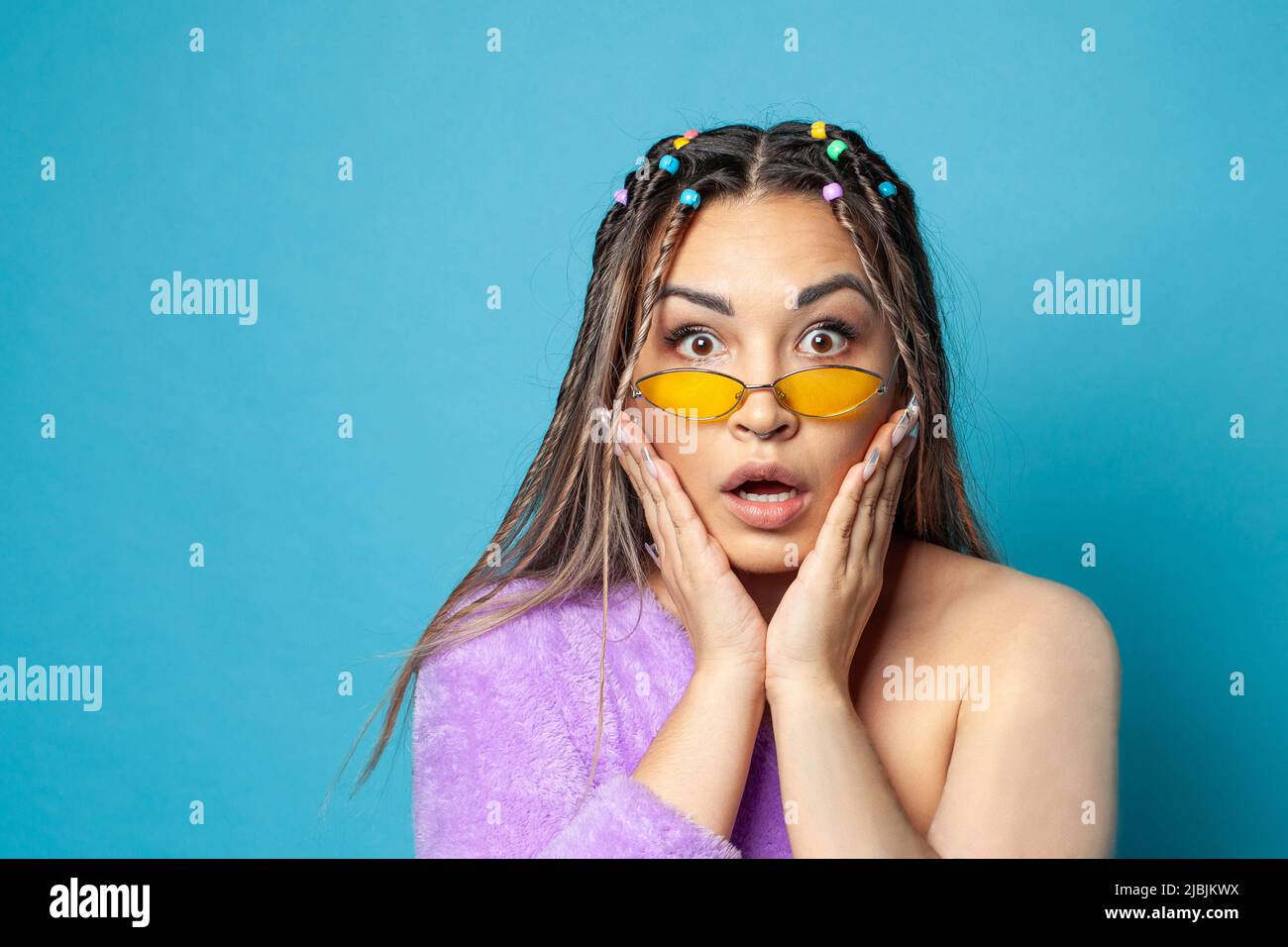 Attractive young female model woman surprise holds cheeks by hand ...