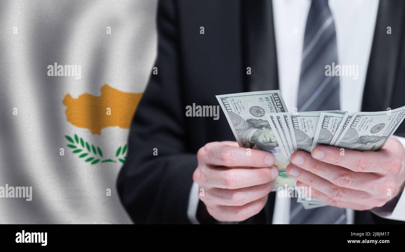 Hands holding dollar money on flag of Cyprus Stock Photo - Alamy