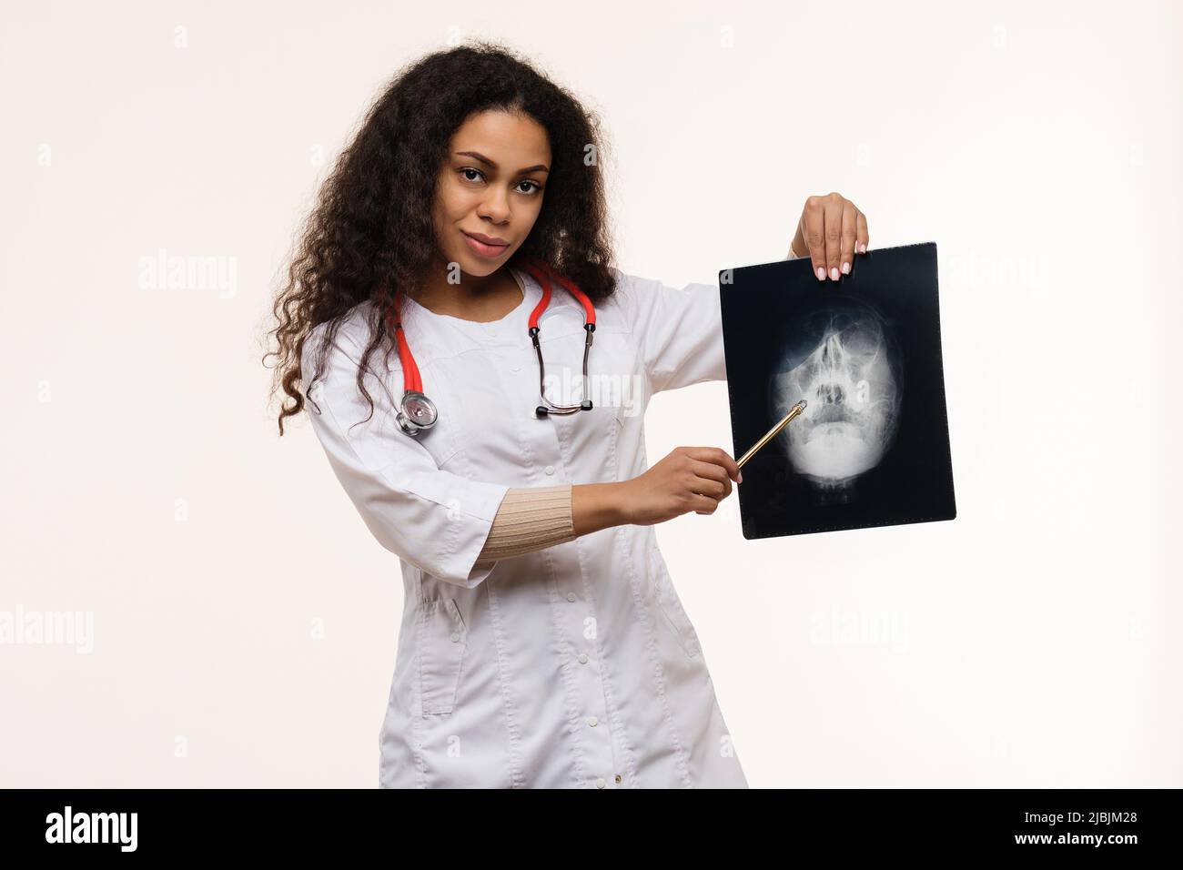 African American Female Doctor Examining X-ray Scan on Light Background ...