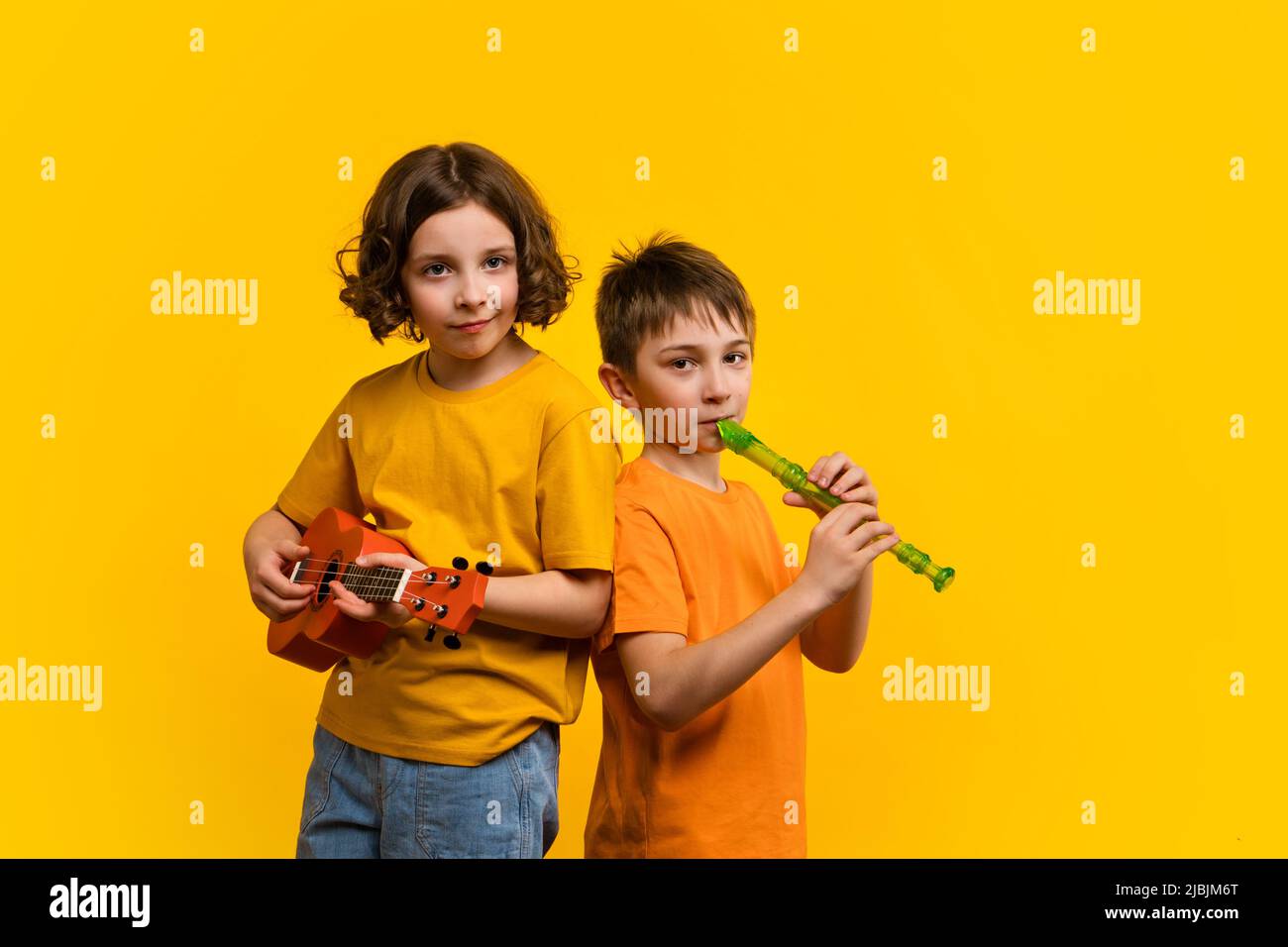 Two children playing musical instruments hi-res stock photography and ...