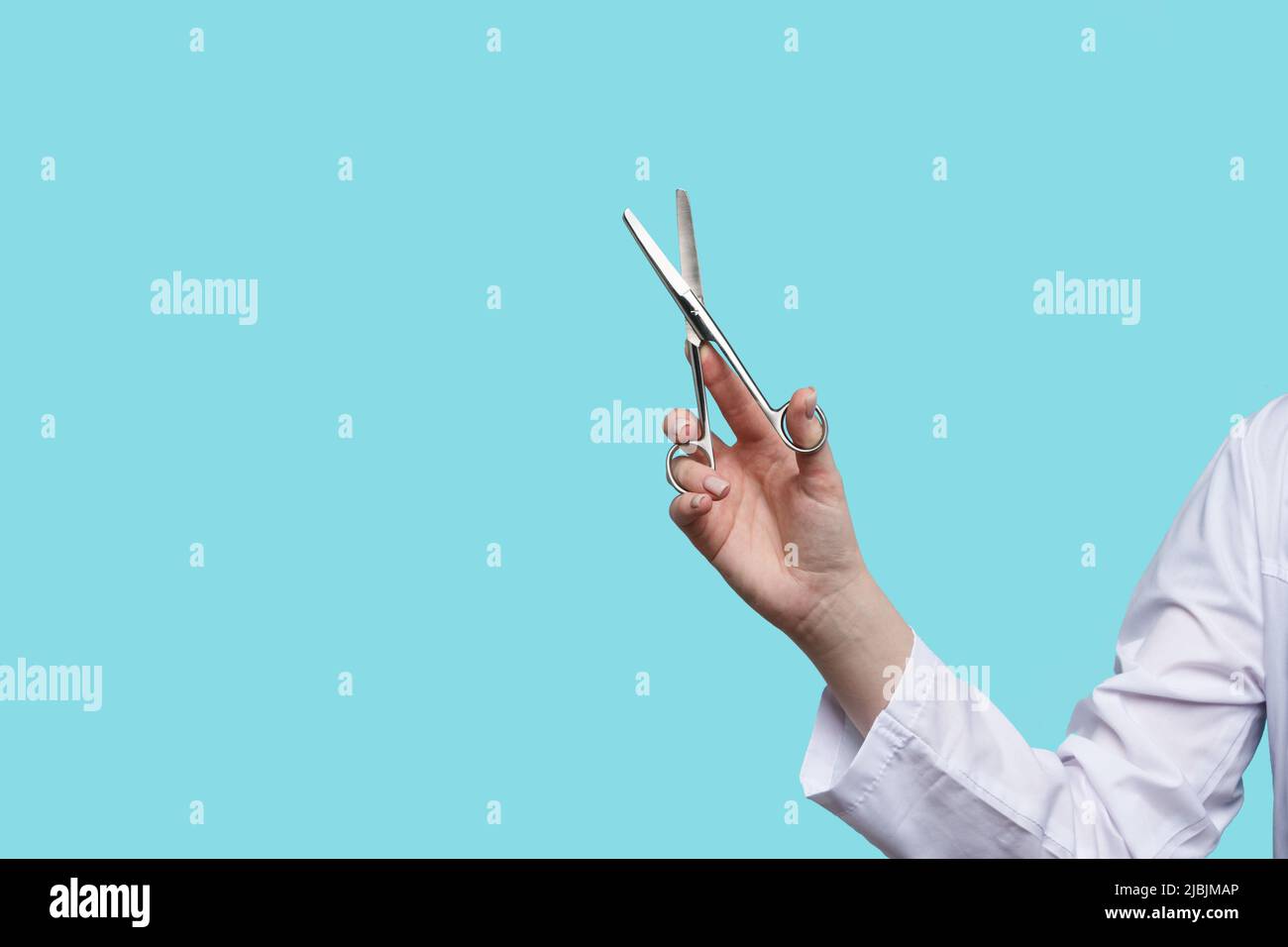 Close up faceless female surgeon holds medical scissors in her hand for ...