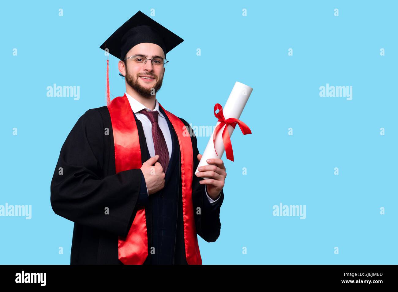 Graduate Male Student Wearing Ceremony Robe and Graduation Cap Holding ...