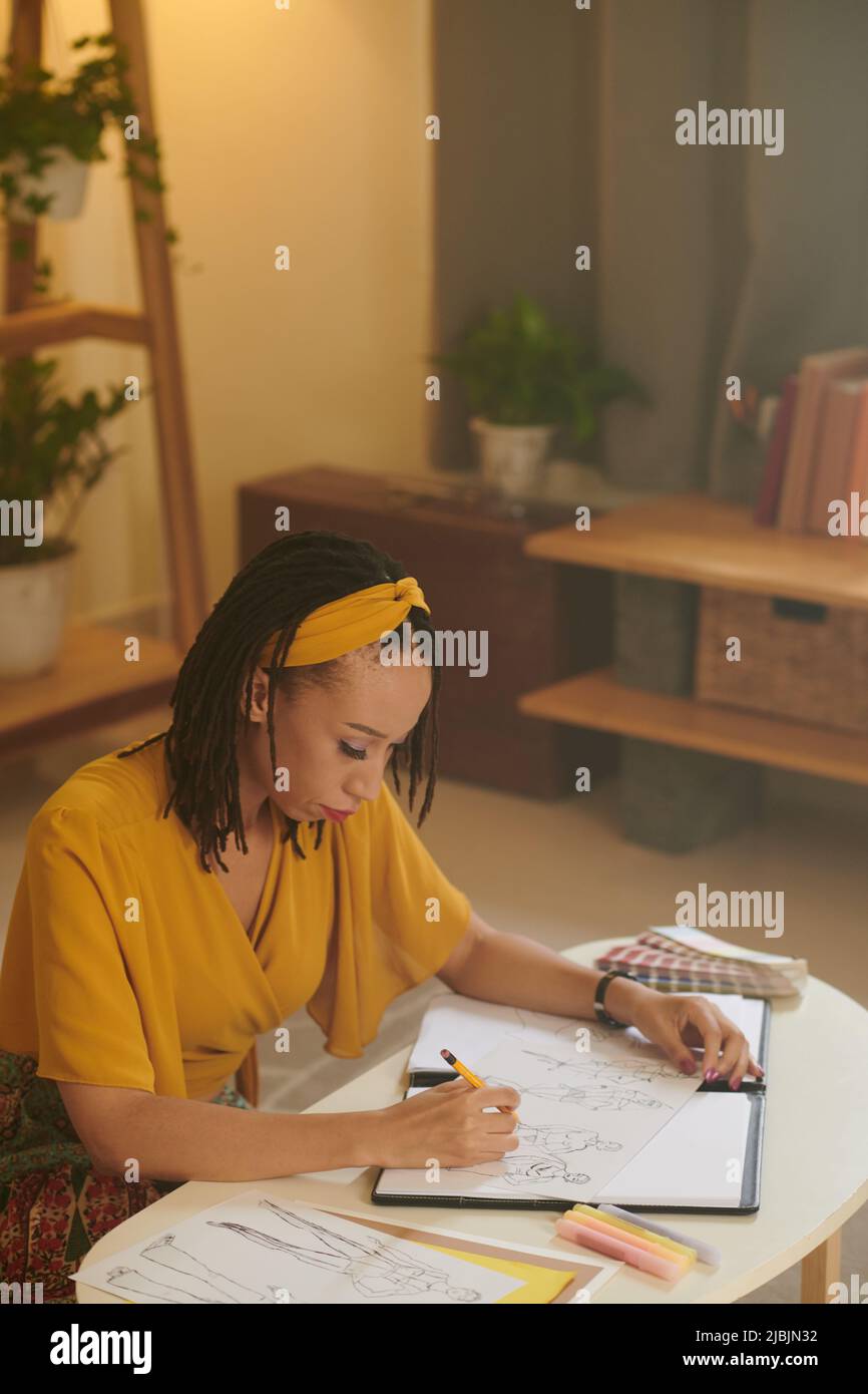 Concentrated talented fashion designer working on new collection ...