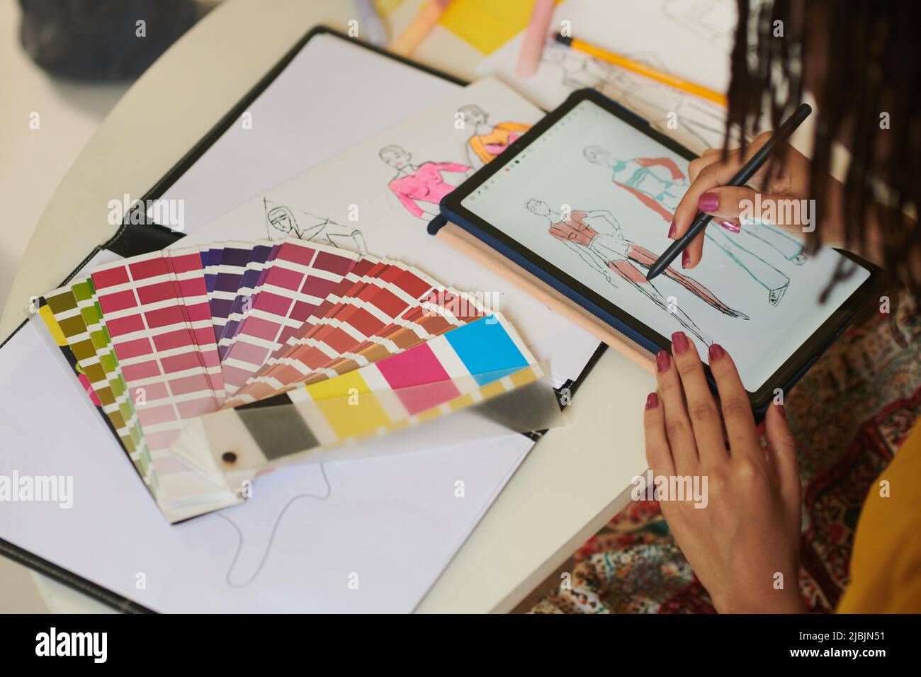 Hands of female designer drawing fashion illustrations on tablet ...