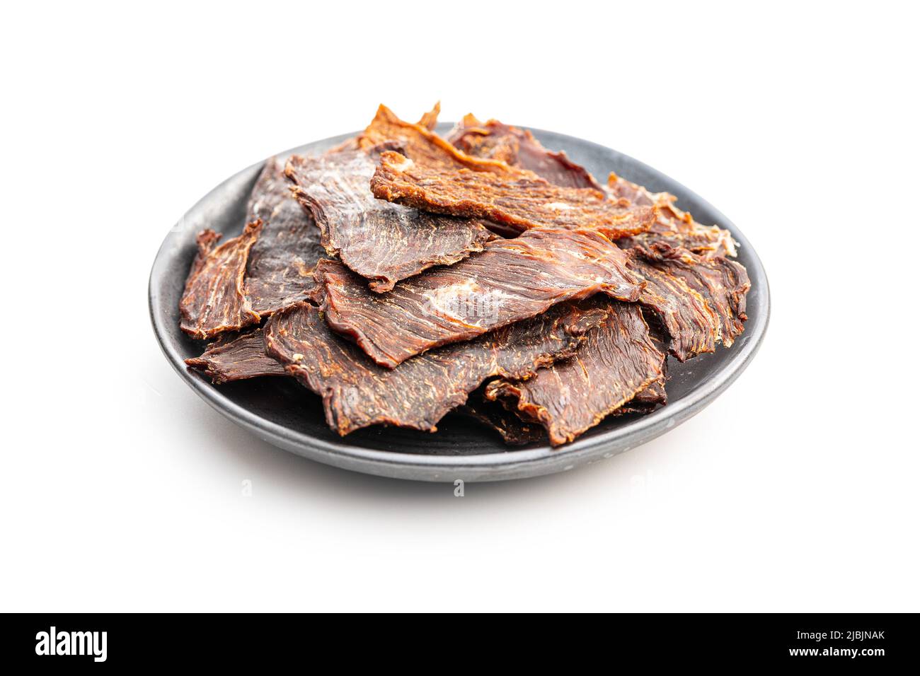 Beef jerky meat on plate. Dried sliced meat isolated on a white ...