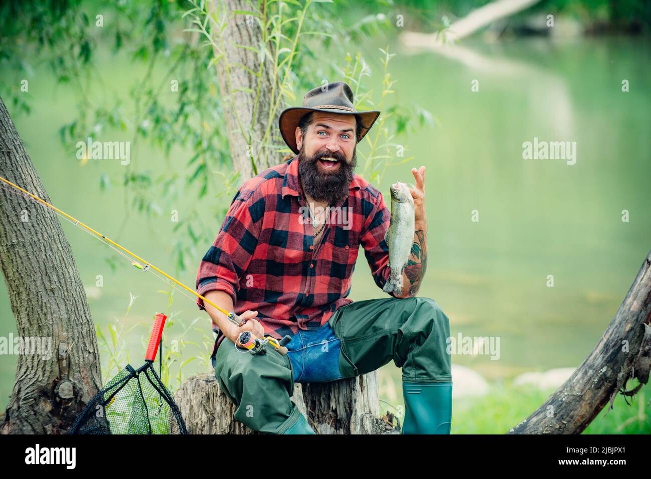 Fisherman caught a fish. Man fishing on river Stock Photo - Alamy