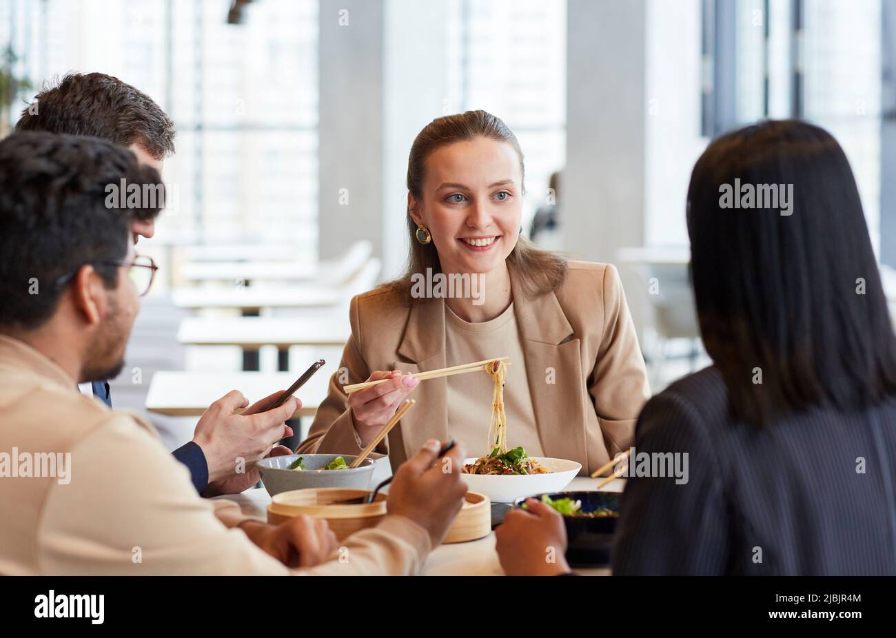 Portrait of smiling businesswoman enjoying business lunch with ...