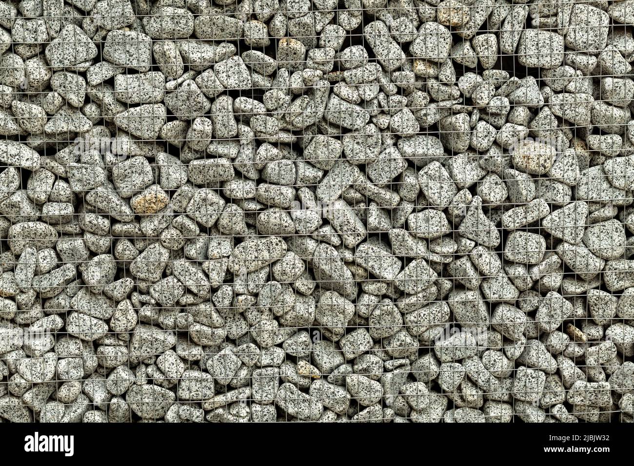 Textured background of a stone wall with iron netting. Stone wall in ...