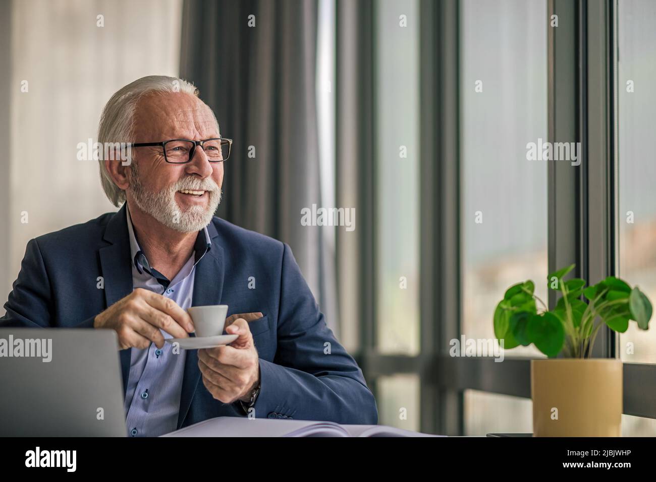 Senior businessman drinking coffee while working on laptop. Elderly ... Senior businessman drinking coffee while working on laptop. Elderly ...
