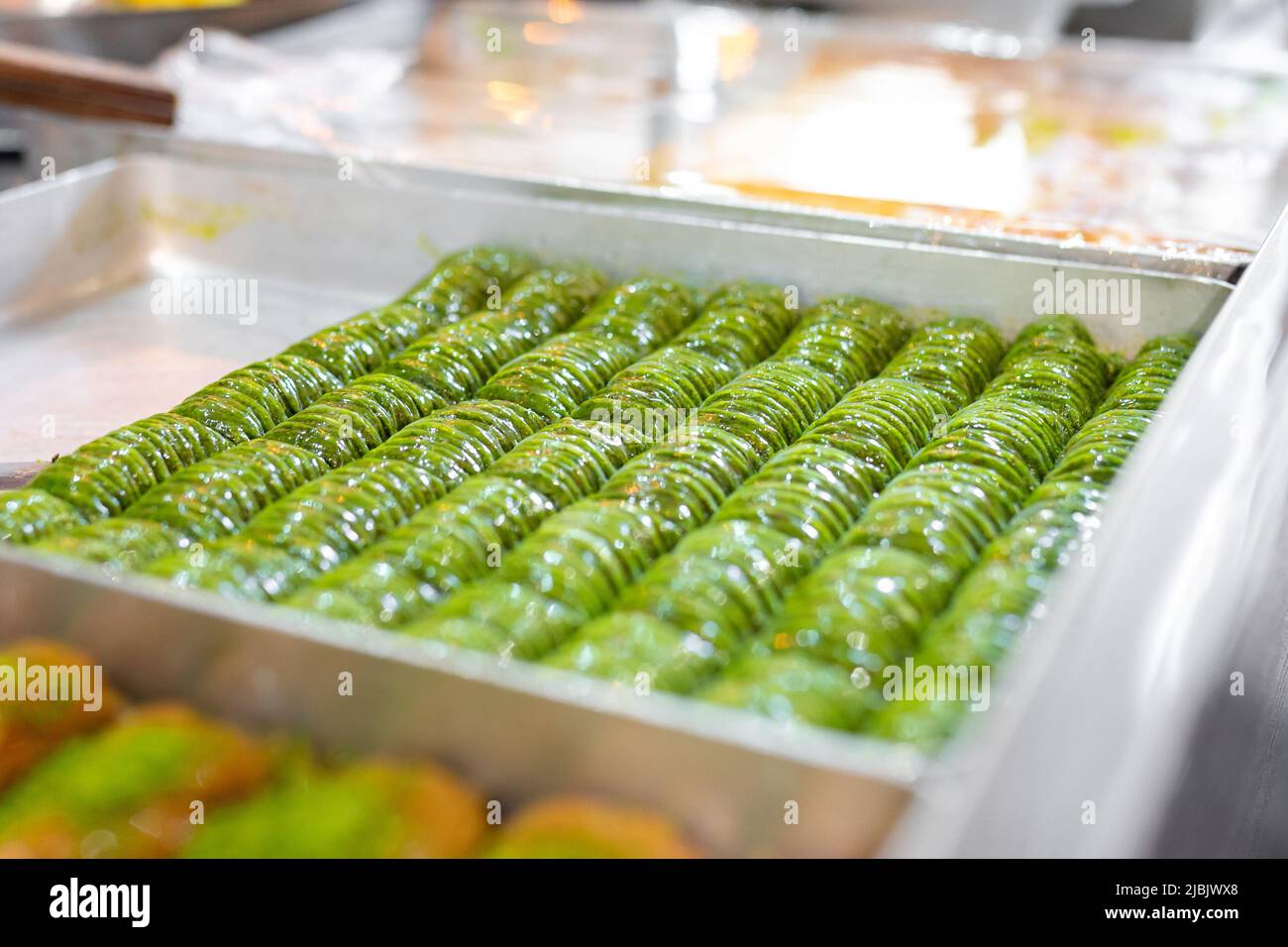 Green pistachio baklava on the counter among other types of baklava ...