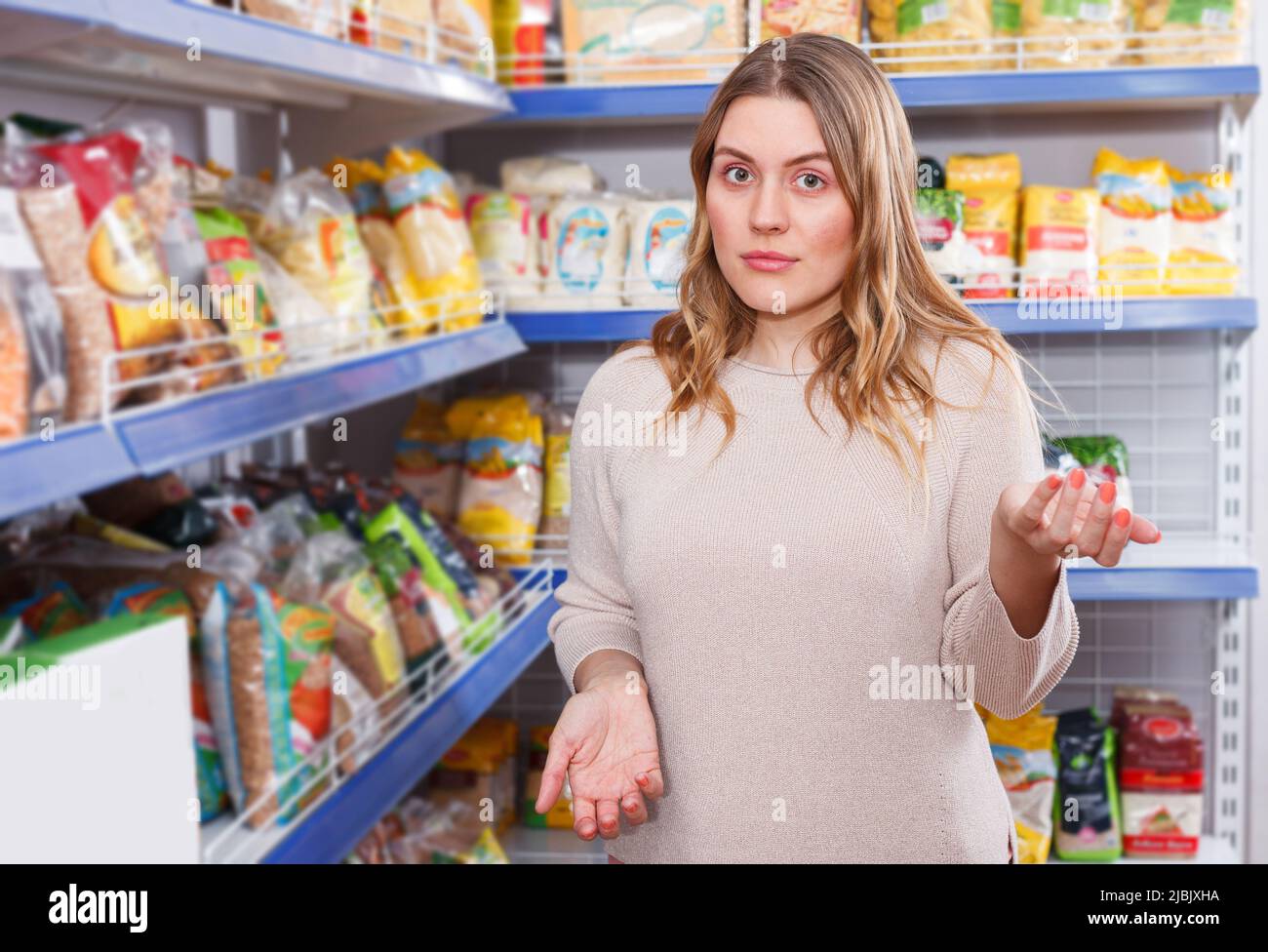 Woman buyer standing near assortment of grocery food store Stock Photo ...