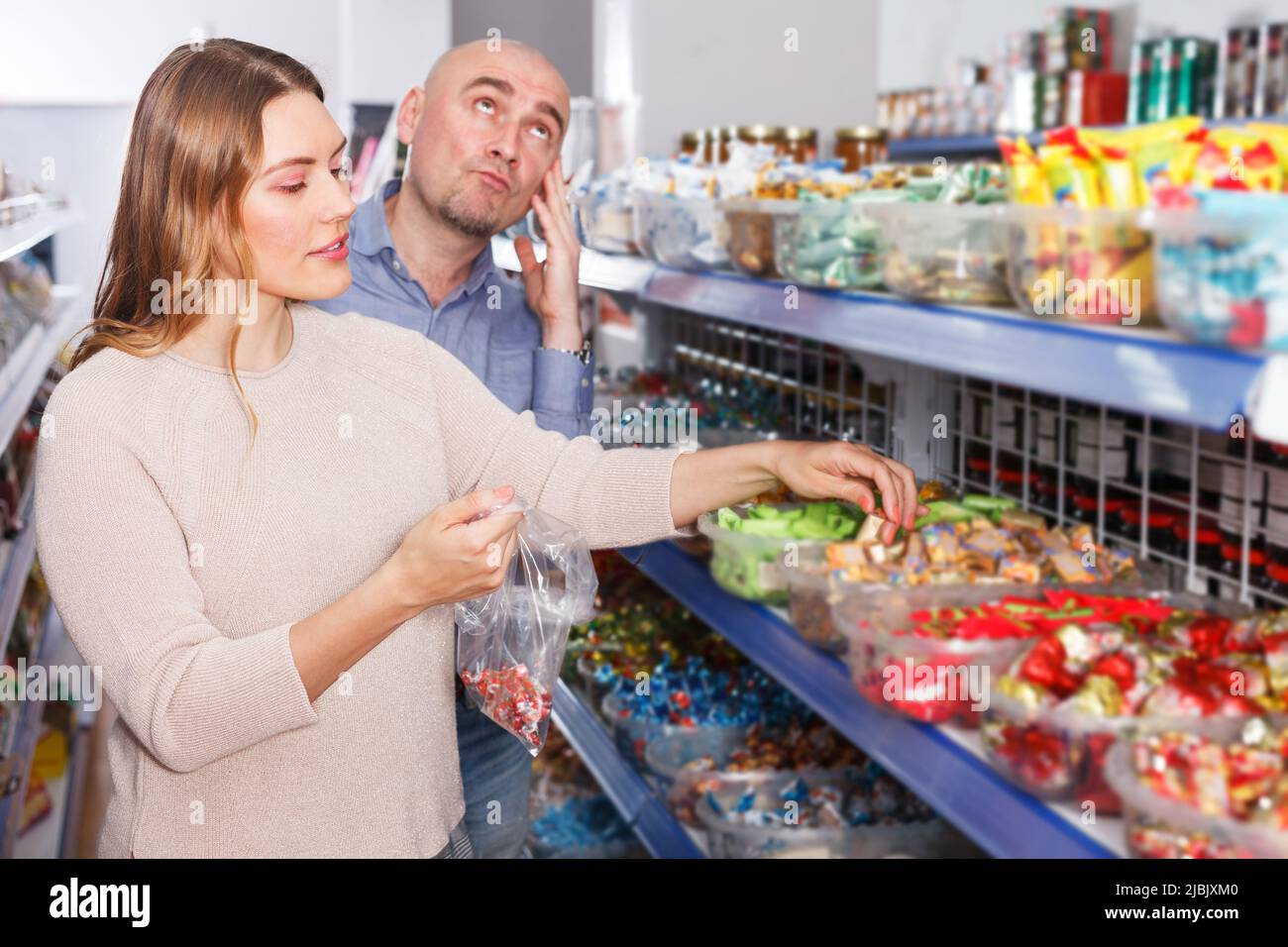 Couple choosing candies in store Stock Photo - Alamy