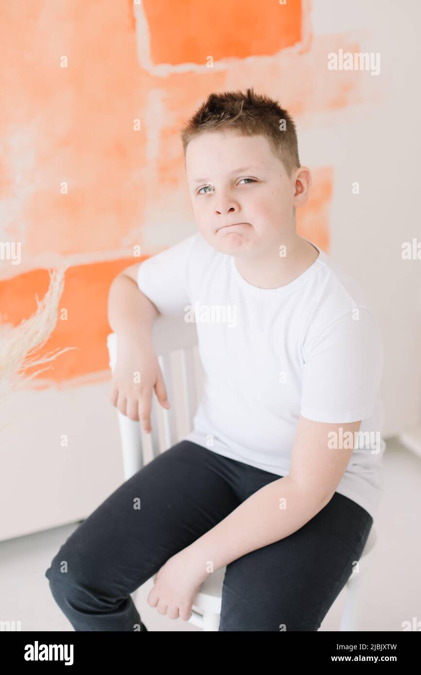 Close up portrait of a happy cute boy in a white t-shirt looking at ...