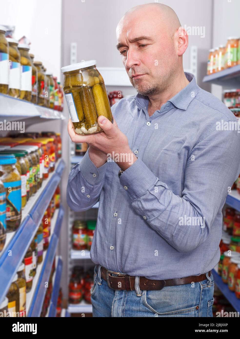 Man customer choosing pickle goods in food store Stock Photo - Alamy