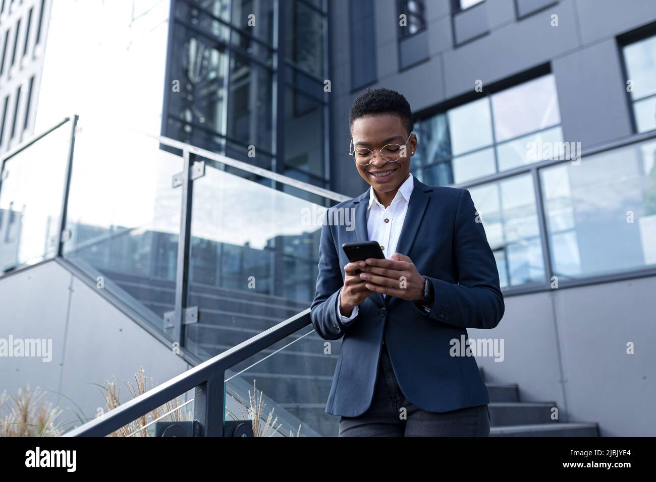 Business woman enjoys cellphone fun and smiling, African American boss ...