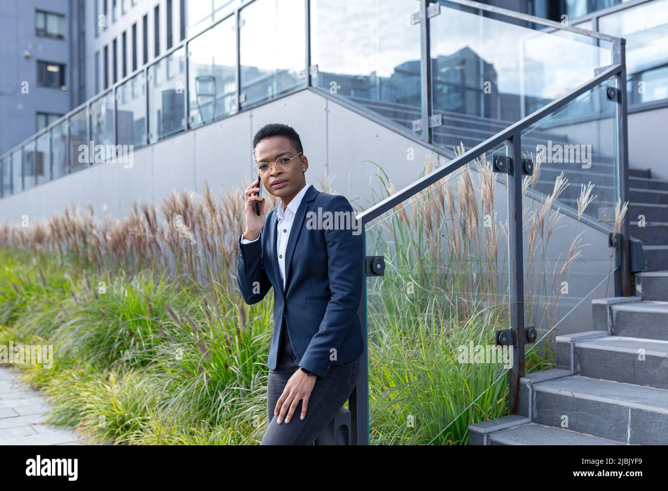 Angry and serious businesswoman talking on the phone outside the office ...
