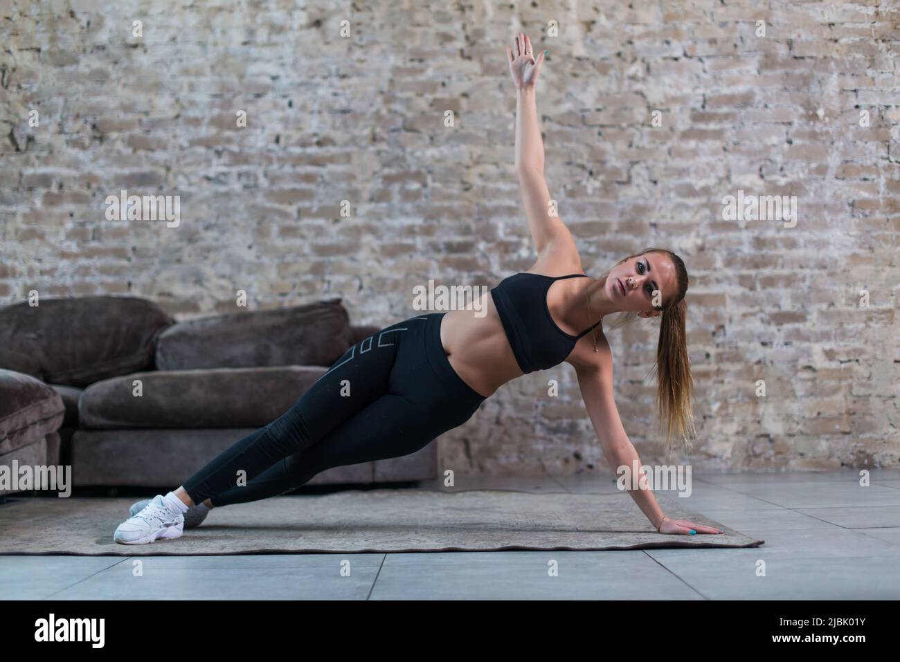 Sporty Caucasian girl doing side plank star exercise working abs and ...