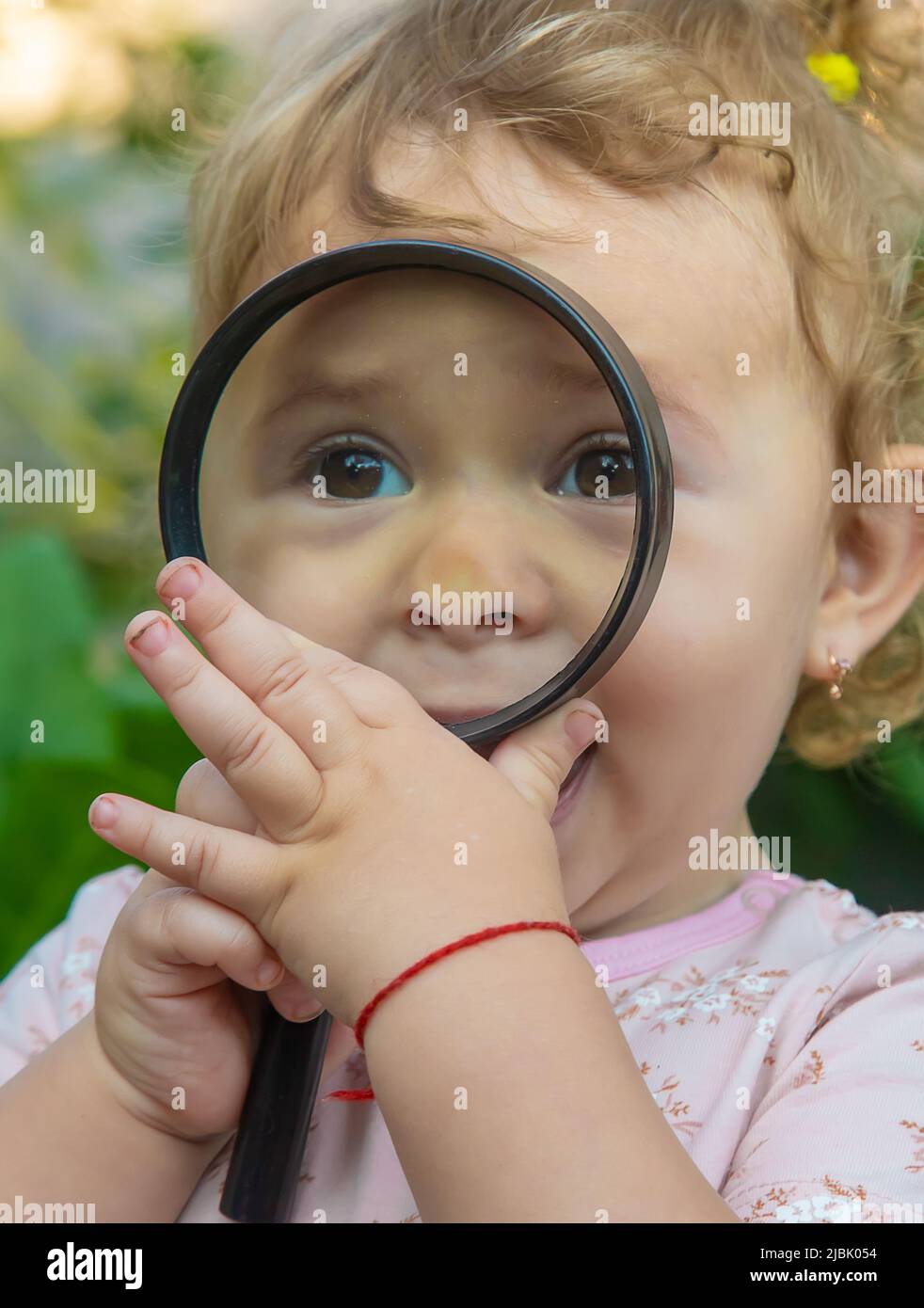 A child with a magnifying glass is studying the world. Selective focus ...