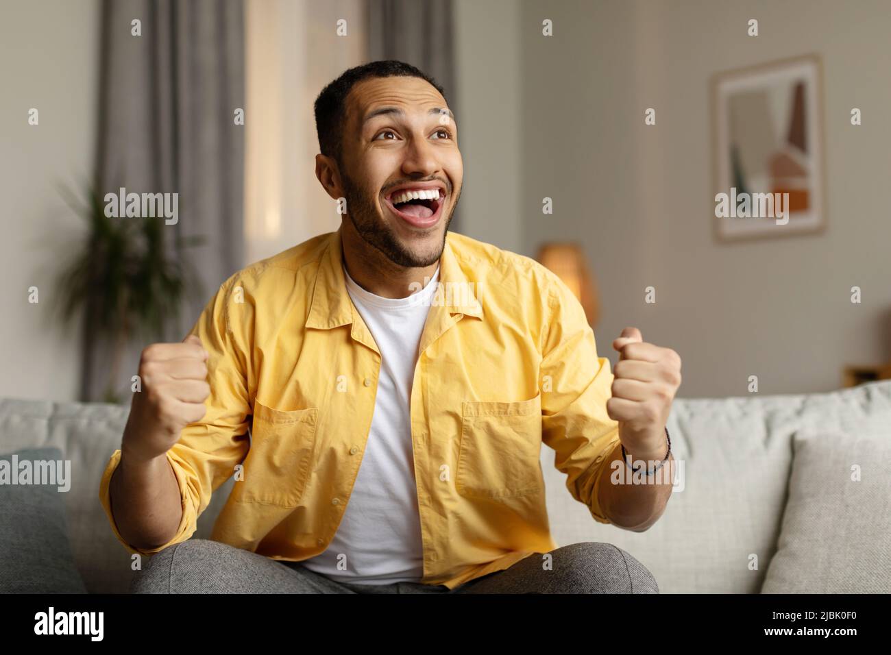 Excited young black man gesturing YES, celebrating success or big win ...