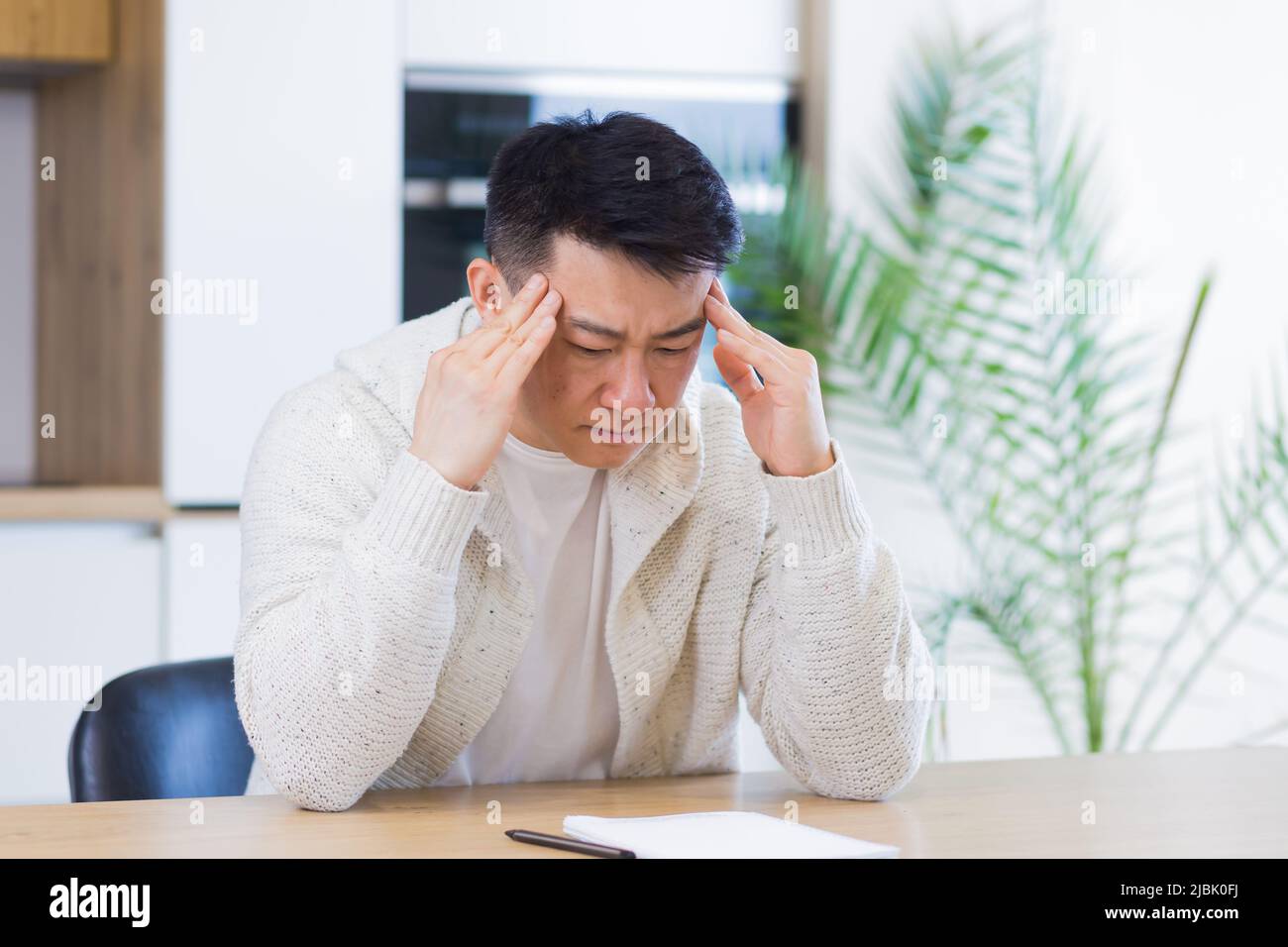 Thoughtful serious young asian man looking away. student writer sit at ... Thoughtful serious young asian man looking away. student writer sit at ...