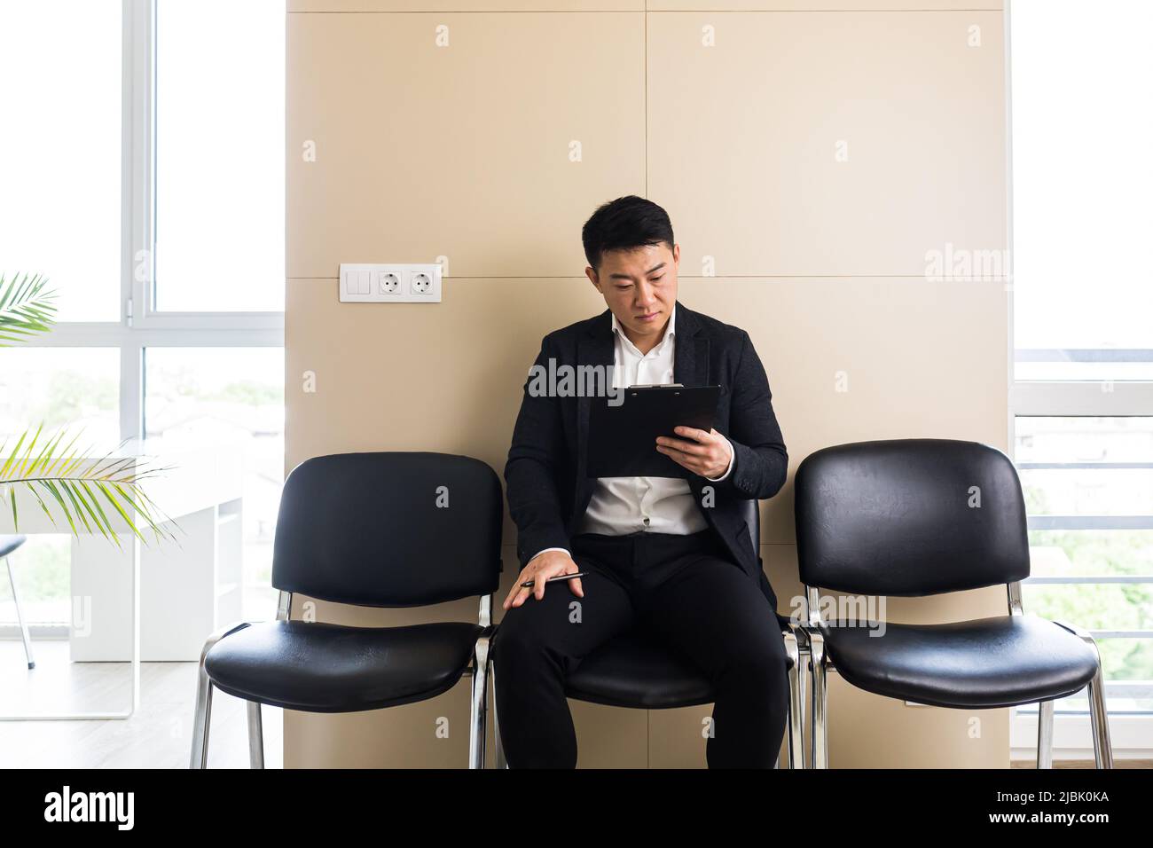 Young successful Asian man, waiting for a job interview, in the waiting ...