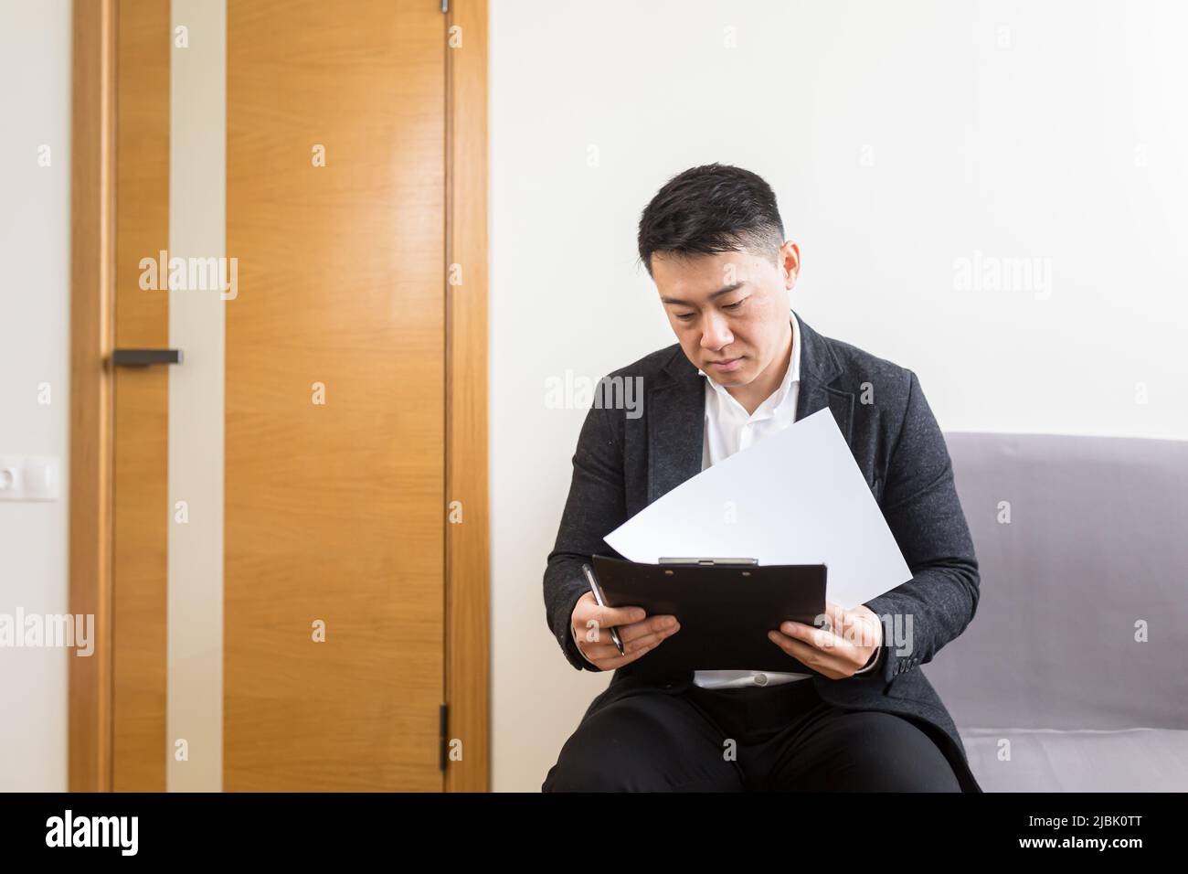 Young successful Asian man, waiting for a job interview, in the waiting ...