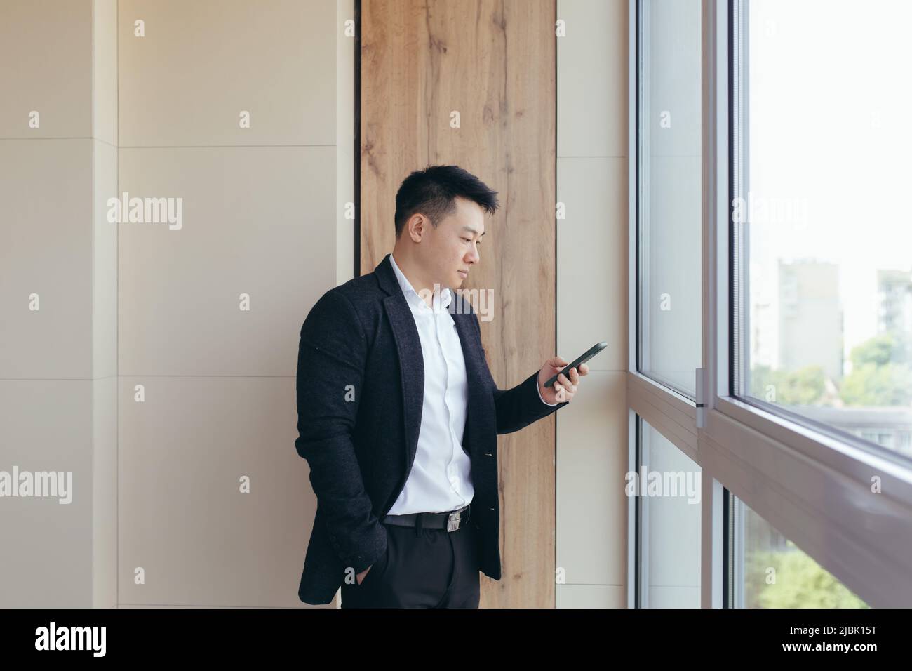 serious boss asian businessman talking on the phone in a modern office ...
