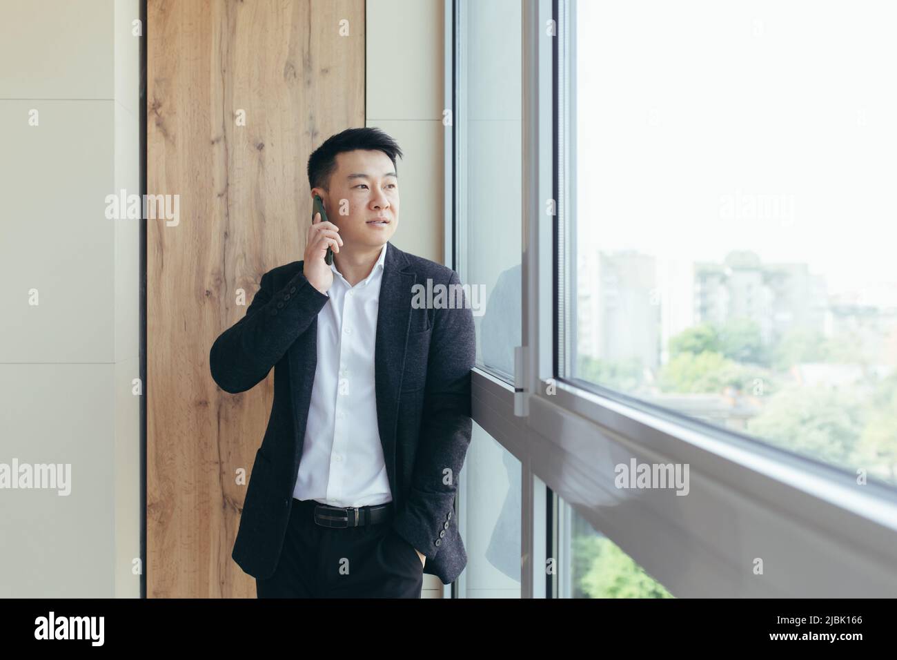 serious boss asian businessman talking on the phone in a modern office ...