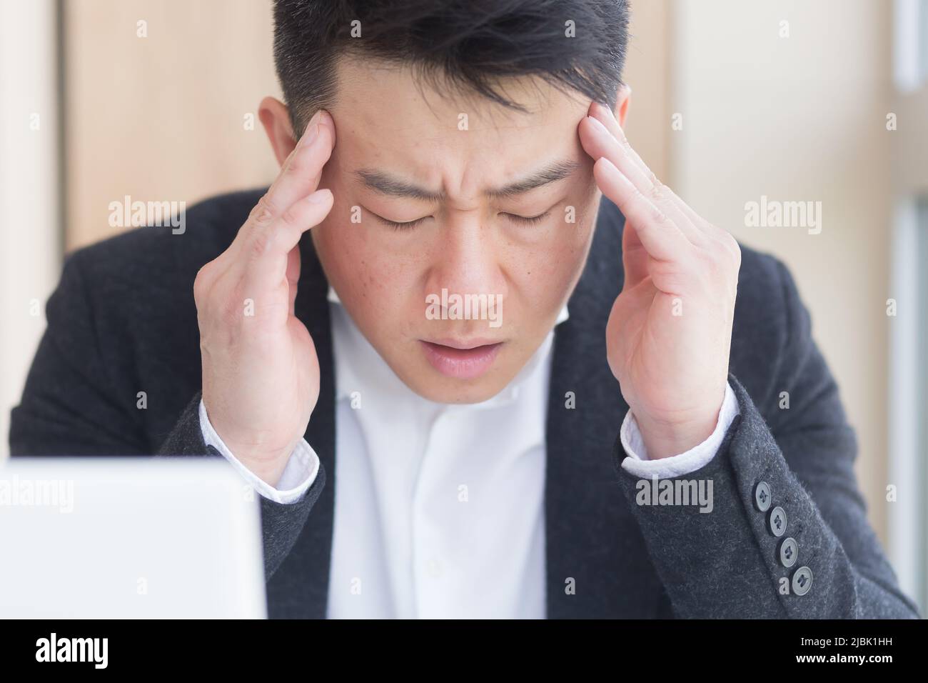 young asian man, office worker sitting at workplace holding hands ...