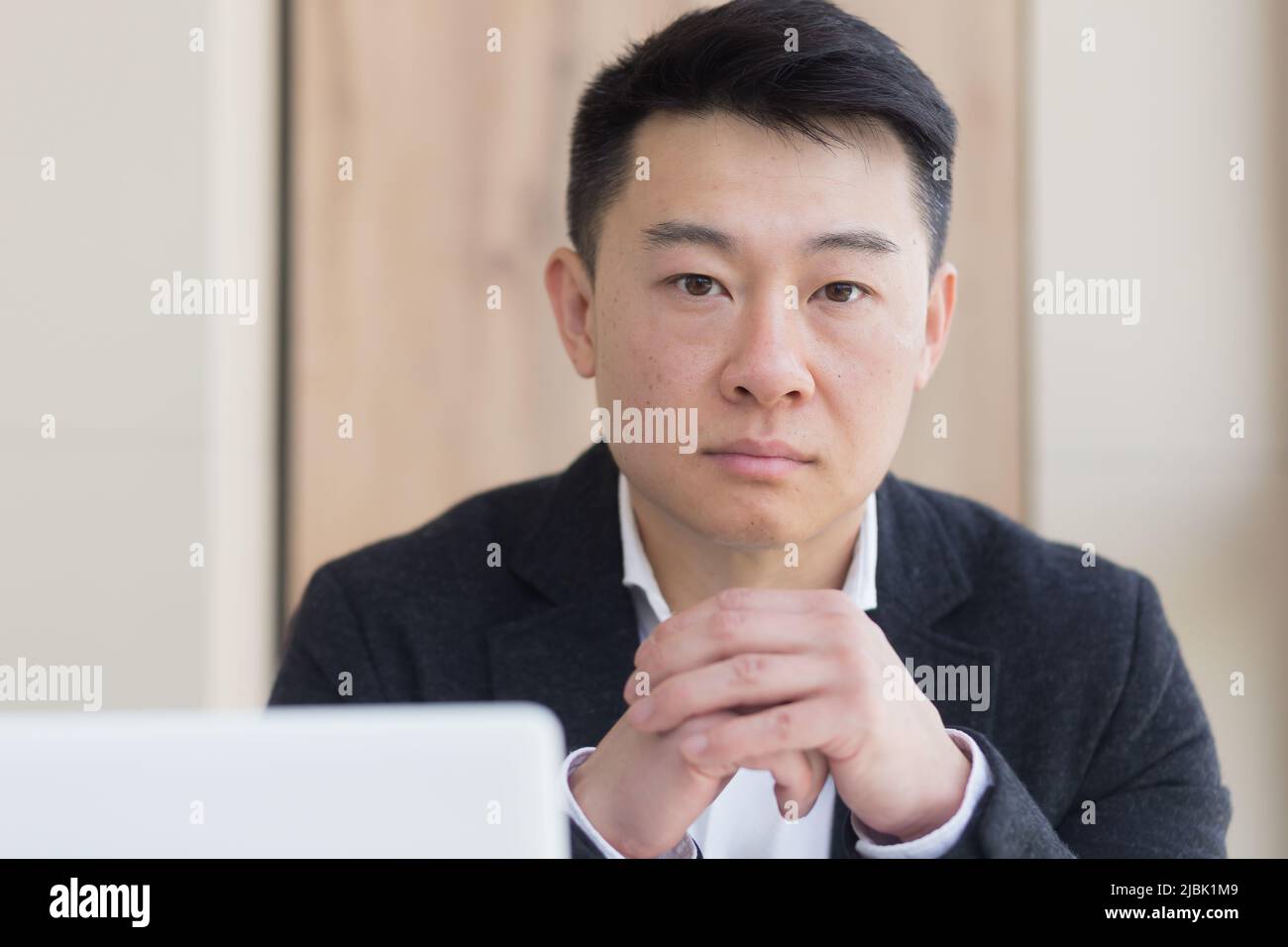 close-up portrait asian pensive young office worker man at workplace ...