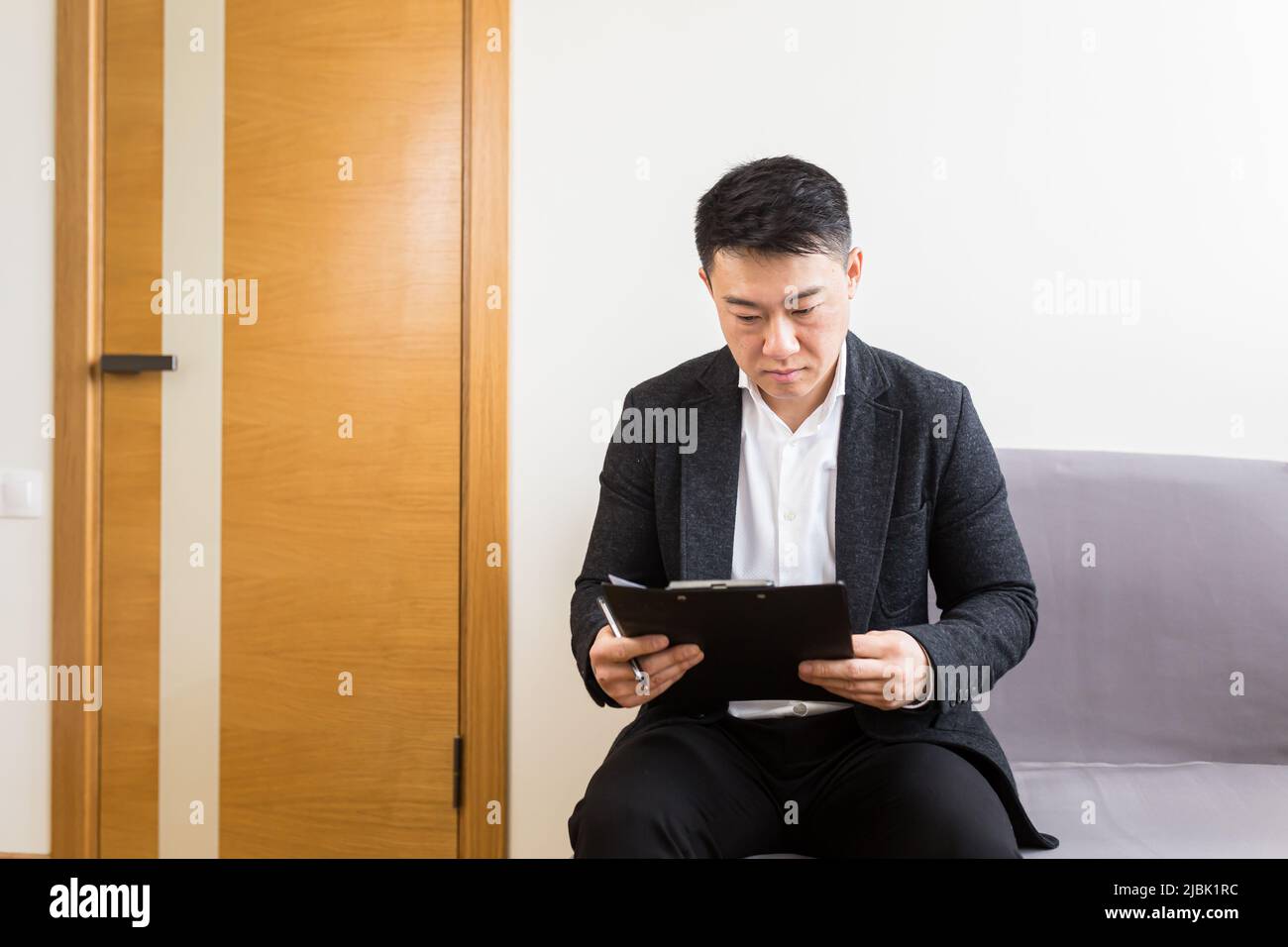 Young successful Asian man, waiting for a job interview, in the waiting ...