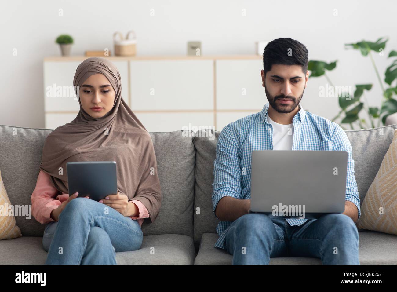 Islamic Husband And Wife Using Digital Tablet And Laptop Indoor Stock ...