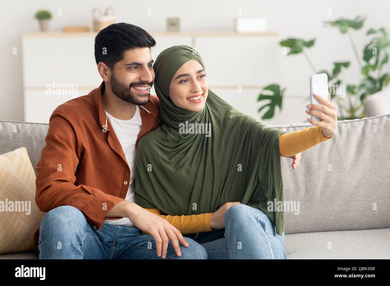 Happy Muslim Husband And Wife Making Selfie On Smartphone Indoor Stock ...