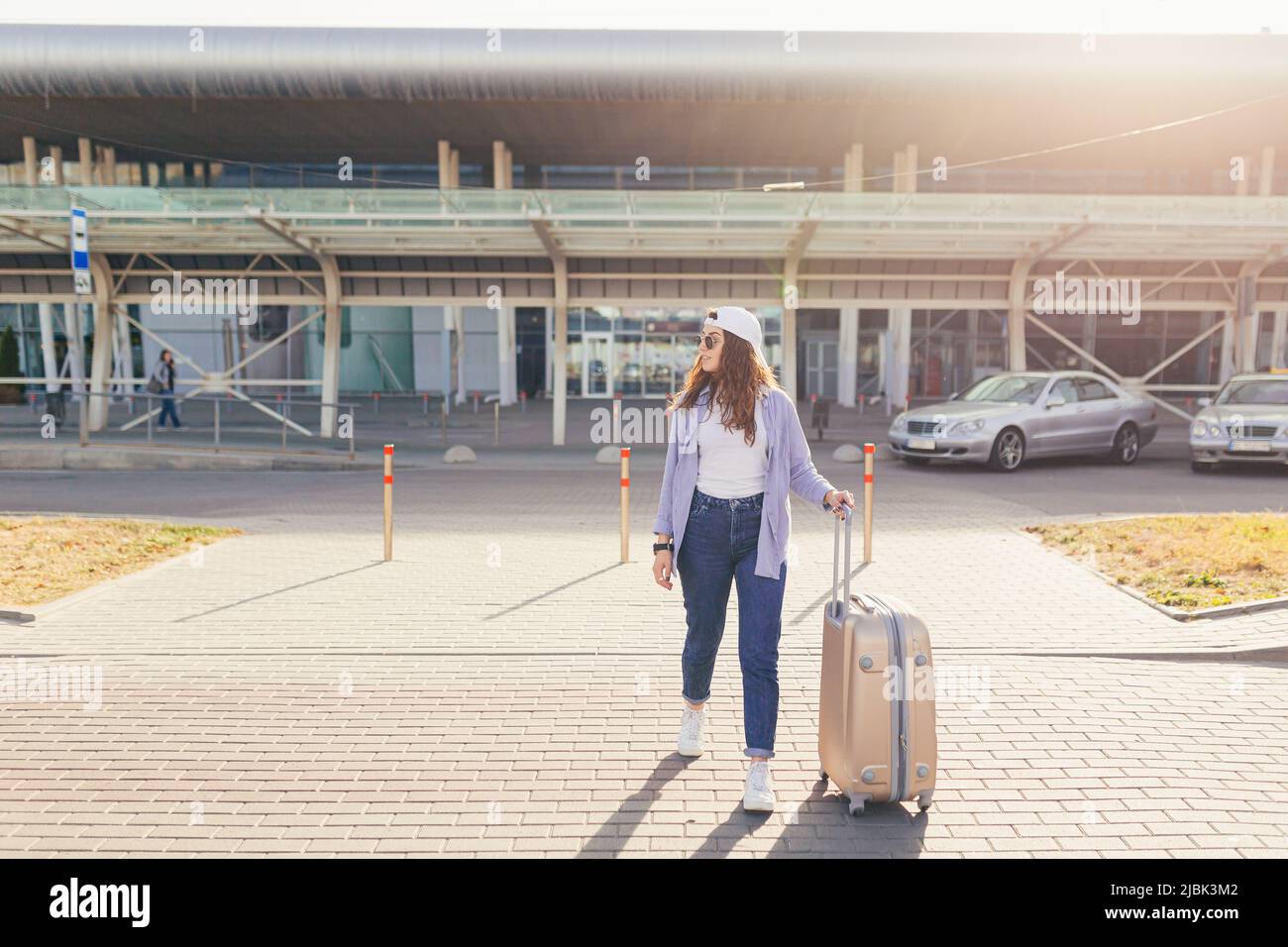 young beautiful girl at the airport, with luggage goes on a plane ...