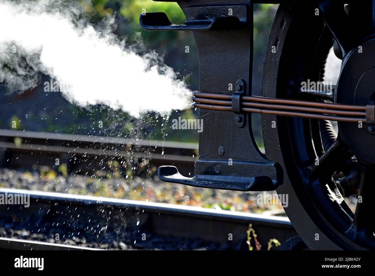 Steam escapes from a steam locomotives cylinder drain cock vent pipes ...
