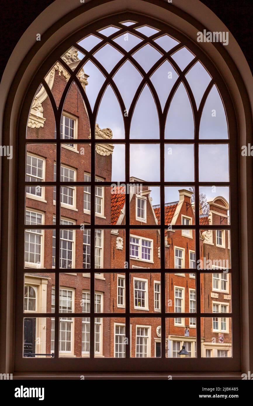 View through the window of a church at the inner court of the Begijnhof ...