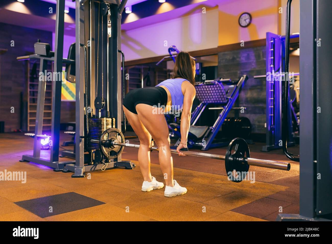 Young beautiful woman, trainer, training in the gym, exercises with ...