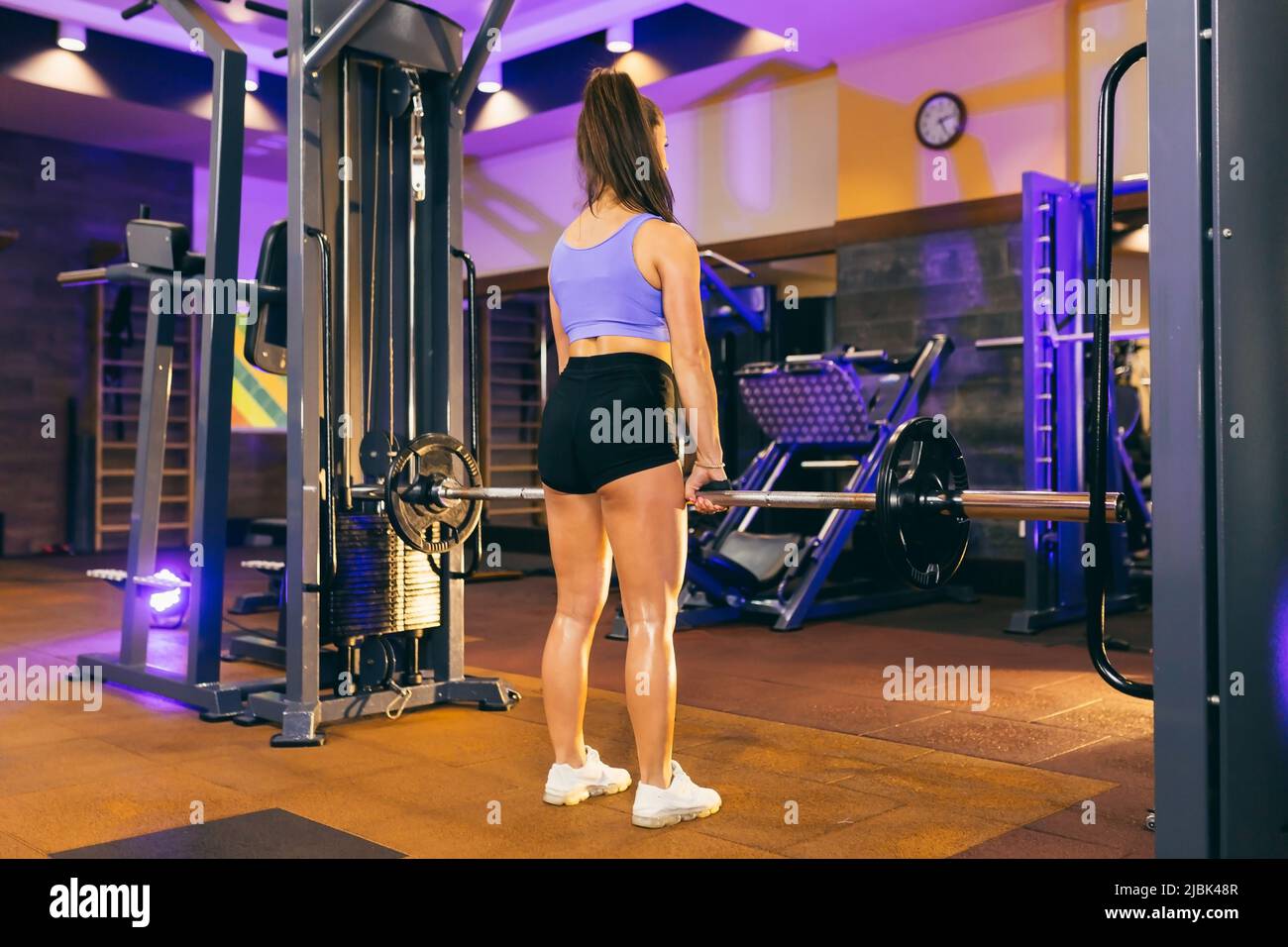 Young beautiful woman, trainer, training in the gym, exercises with ...