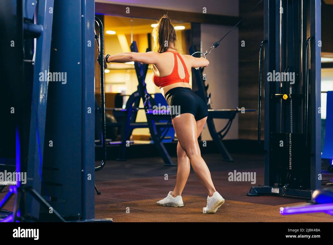 Young beautiful woman, trainer, trains in the gym on the simulator ...